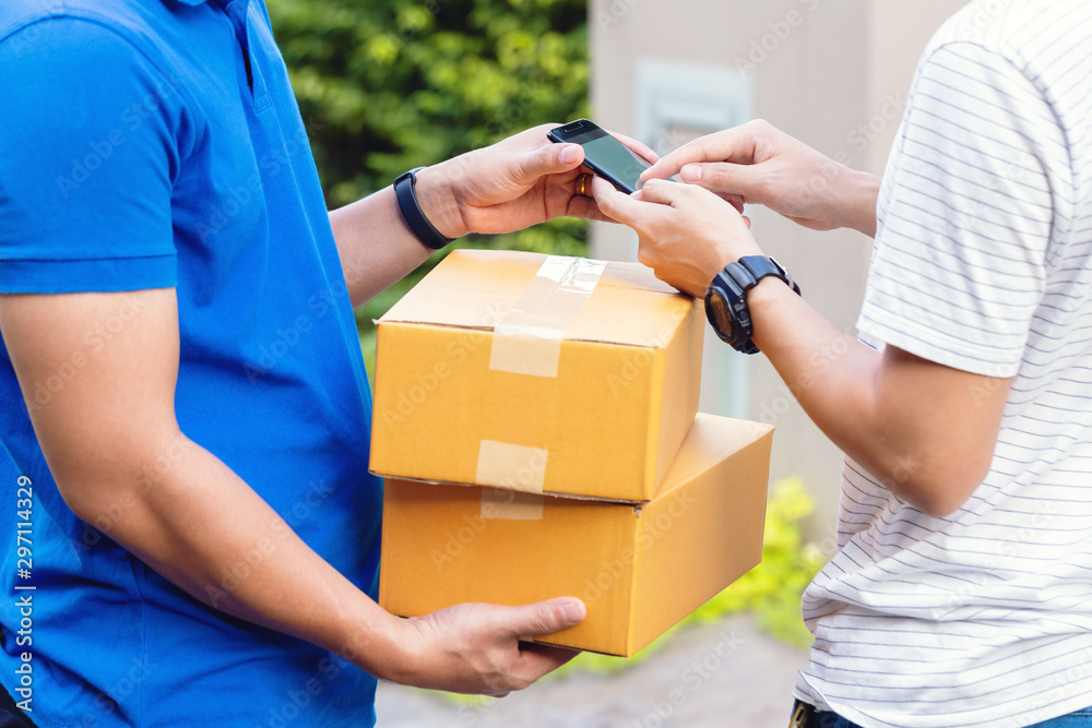 Man receiving package from delivery man appending signature in digital ...