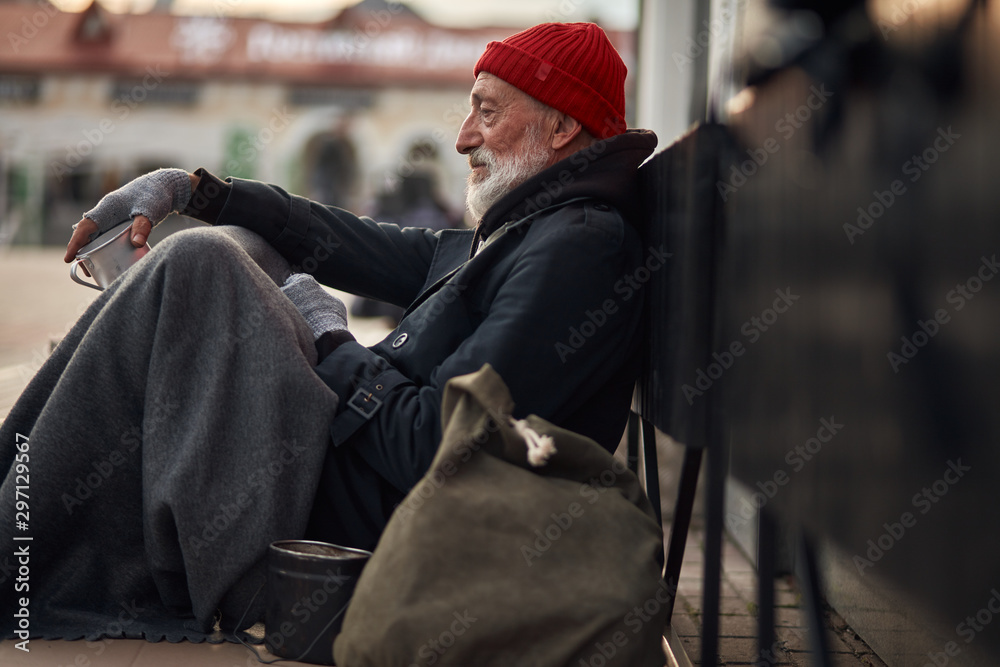 Side view on beggar male on street begging, waiting help by citizens ...