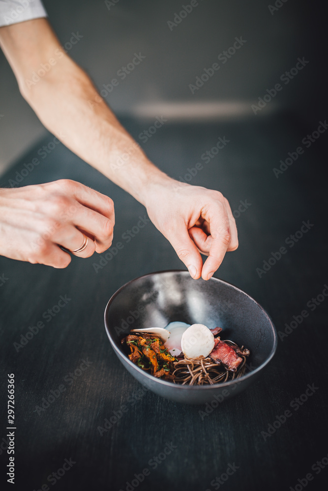 Chef making Miso Ramen Asian noodles with egg, enoki and pak choi ...
