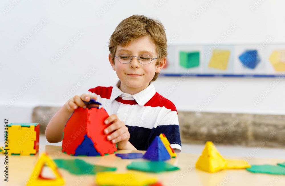 Happy kid boy with glasses having fun with building and creating ...