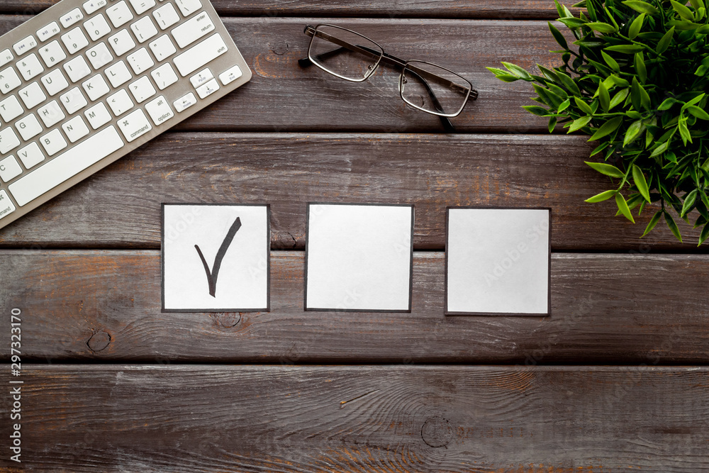 Check mark in check-box of check list on dark wooden office background ...