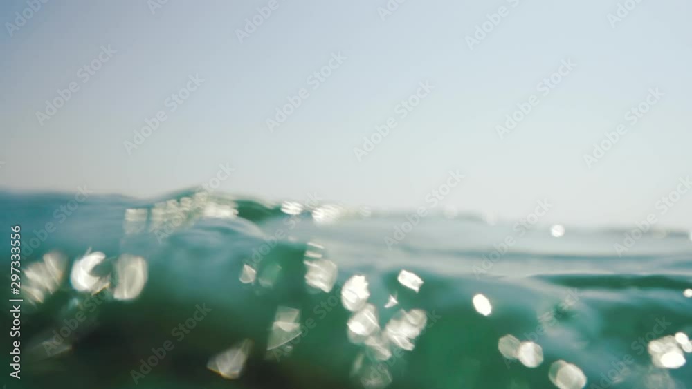 sea waves and underwater view with sunrays shining through the water ...