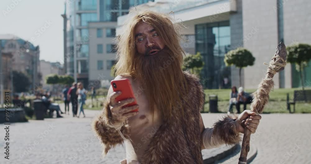 Smiling neanderthal of hunter-gatherers discovering modern device use ... Smiling neanderthal of hunter-gatherers discovering modern device use ...