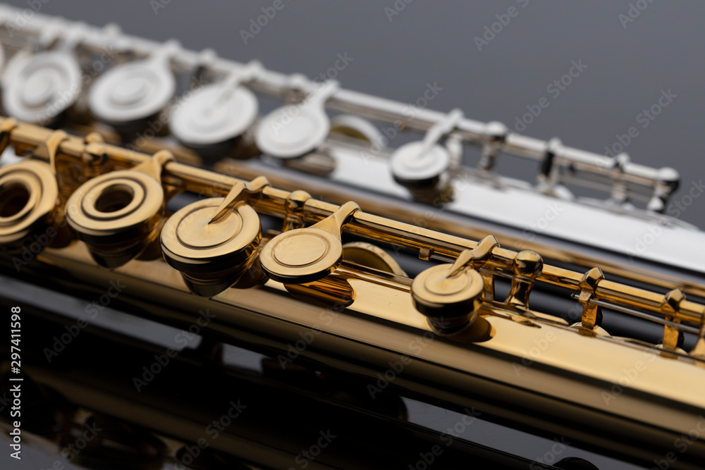 Foto de Two shiny gold and silver plated flutes on a reflective surface ...