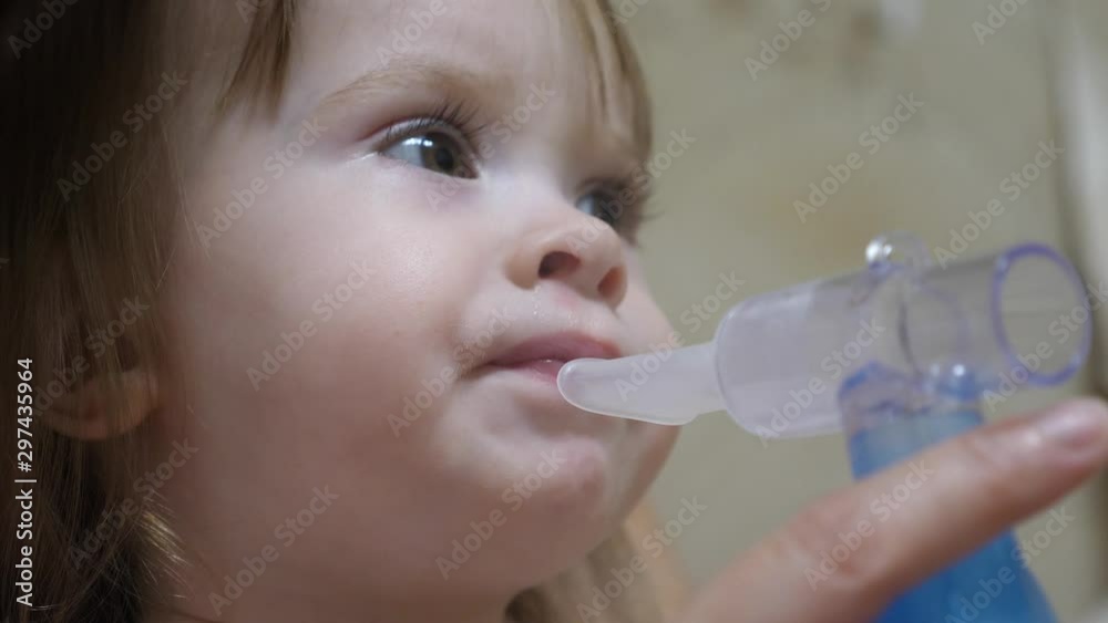 little girl treated with an inhalation mask on her face in hospital ...