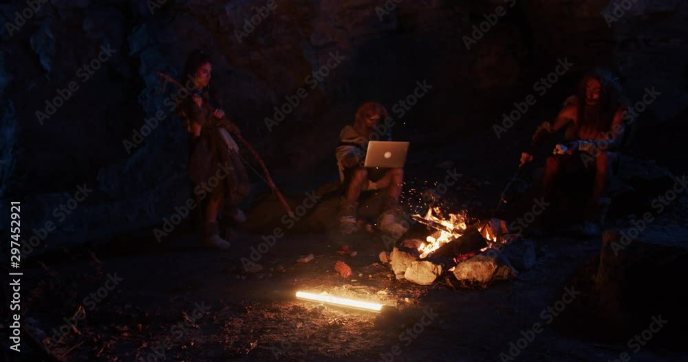 Tribe neanderthals wearing animal skin use tablet computer sitting by ...