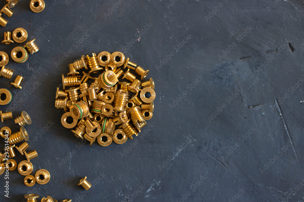 Round form made of gold pop rivet nuts ond lochnuts on black tectured ...