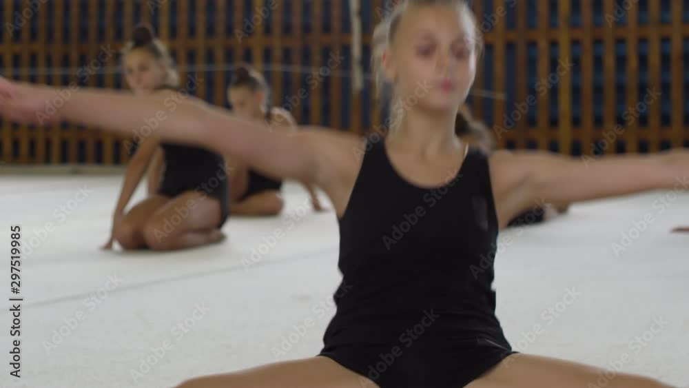 Tilt down shot of teenage girl in sportswear performing rhythmic ...