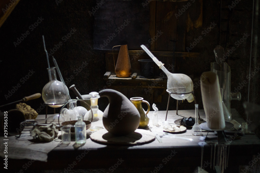 Set of alchemy bottles in laboratory of alchemist. Herb in old pots ...
