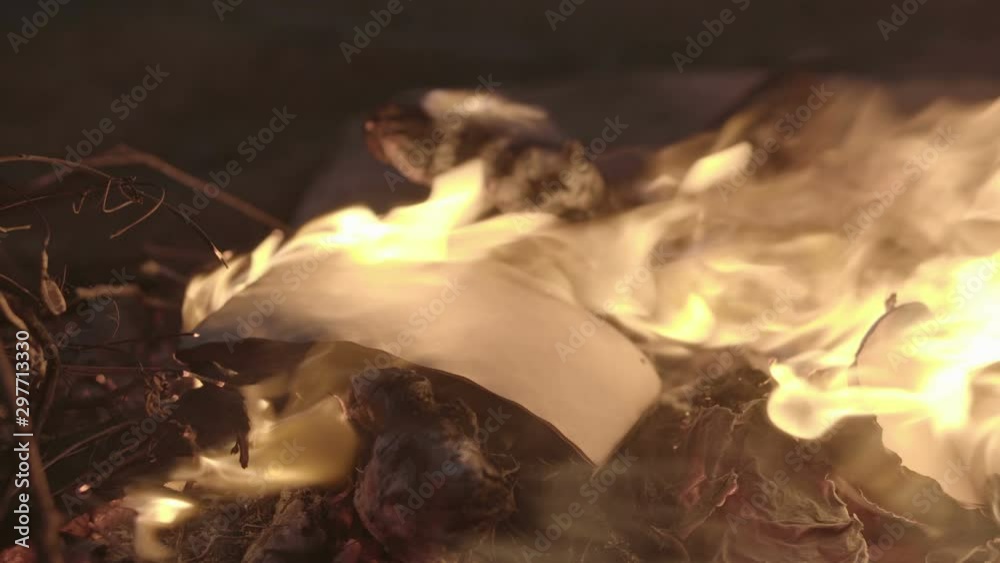 Vintage book page burning in fire flame at night, burn secret old note ...
