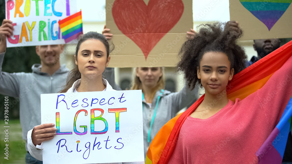 Group of people raising rainbow flags, posters for LGBT rights, gender ...