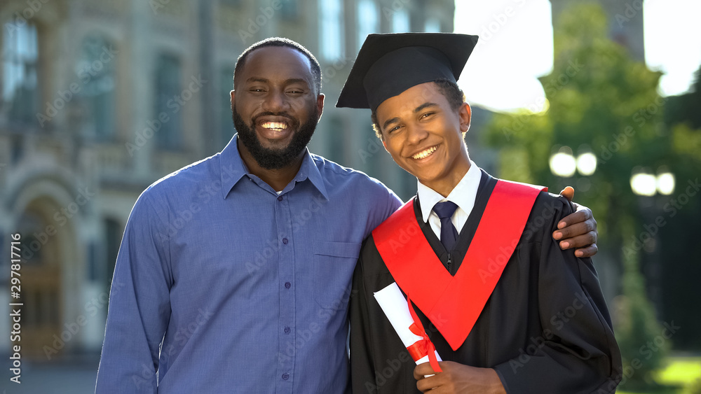 Proud glad father hugging graduating son with diploma, education degree ...