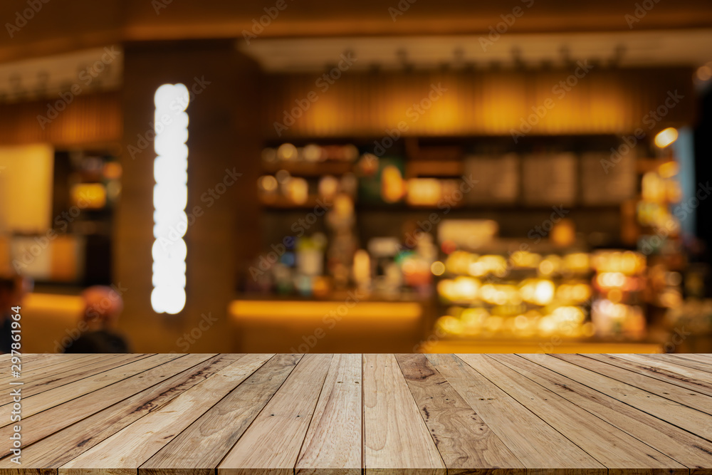 image of wooden table in front of abstract blurred background of coffee ...