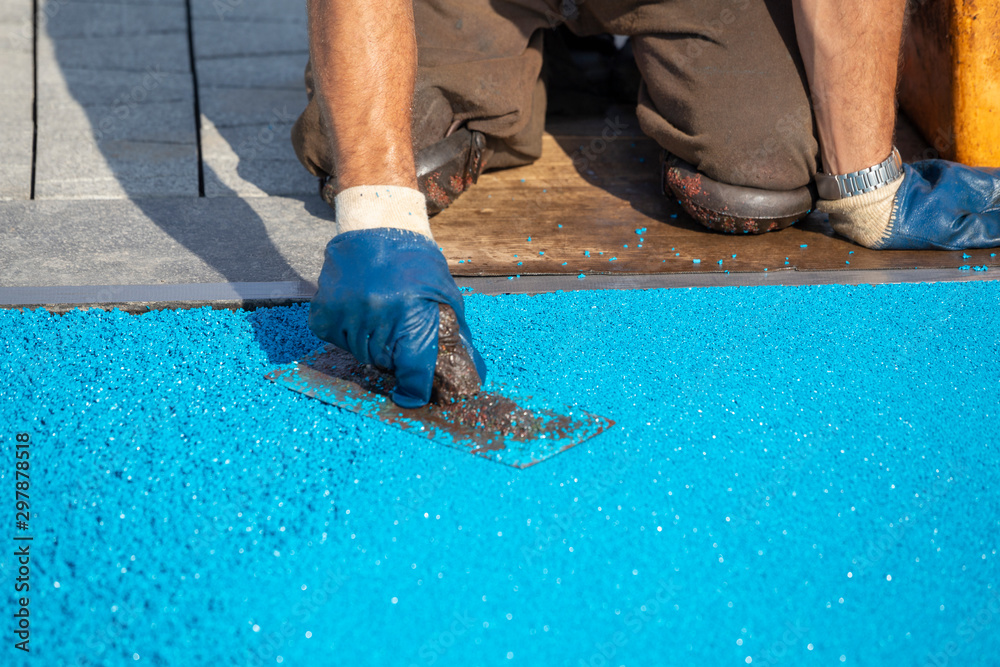 Mason leveling rubber coating for playgrounds with trowel Stock Photo ...