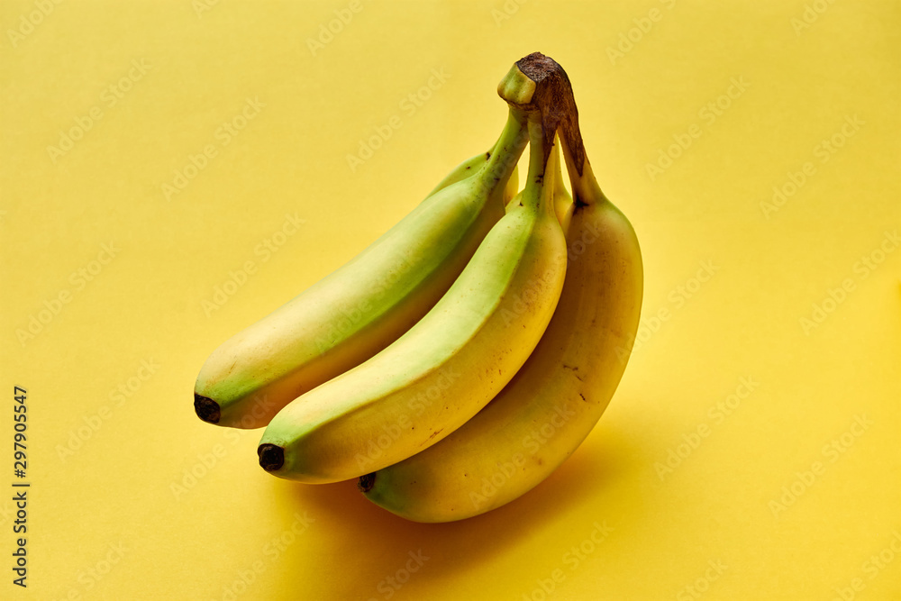 A bunch of bananas. Half ripe organic bananas with green and spots on ...