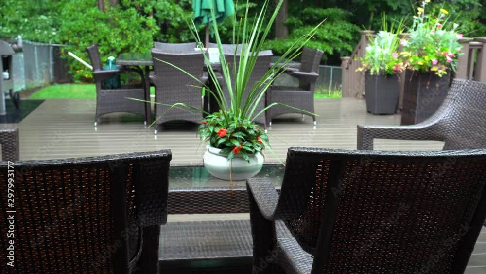 Rain lightly pattering on a suburban deck during a summer storm with ...