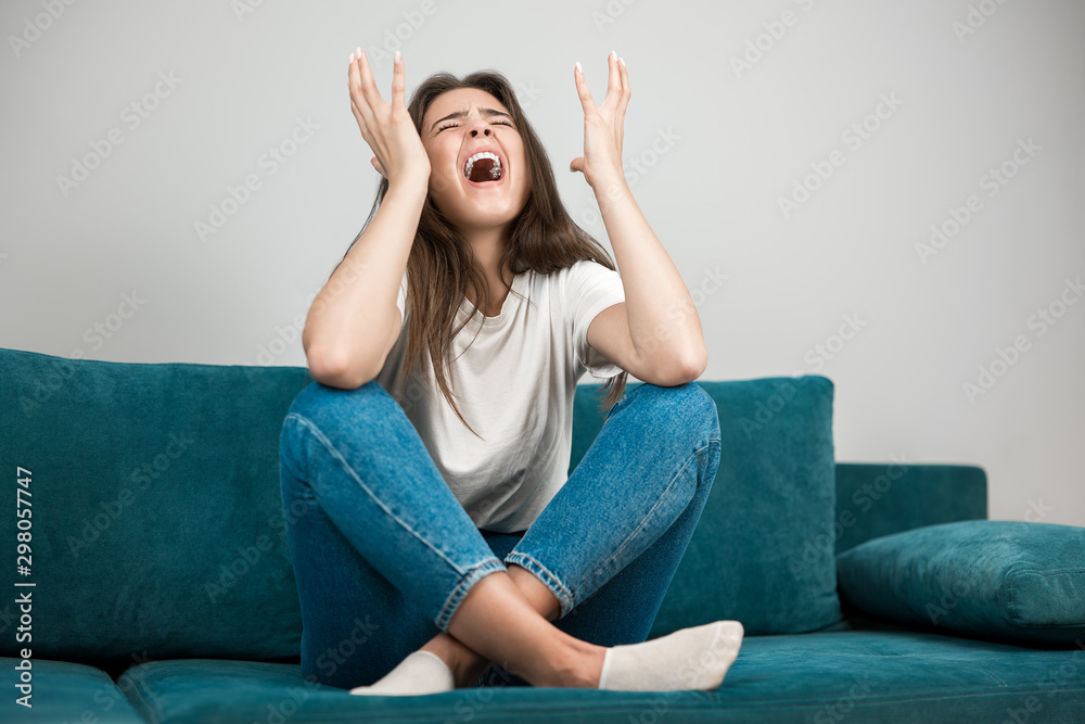 beautiful young woman crying feeling very depressed sitting on the sofa ...