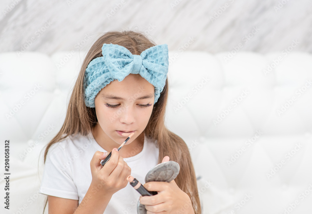 Little girl puts lipstick on hera lips at home Stock Photo | Adobe Stock