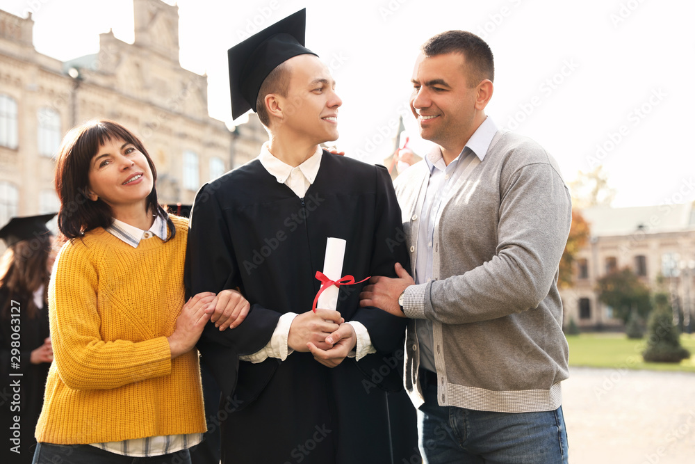 Happy student with parents after graduation ceremony outdoors Stock ...