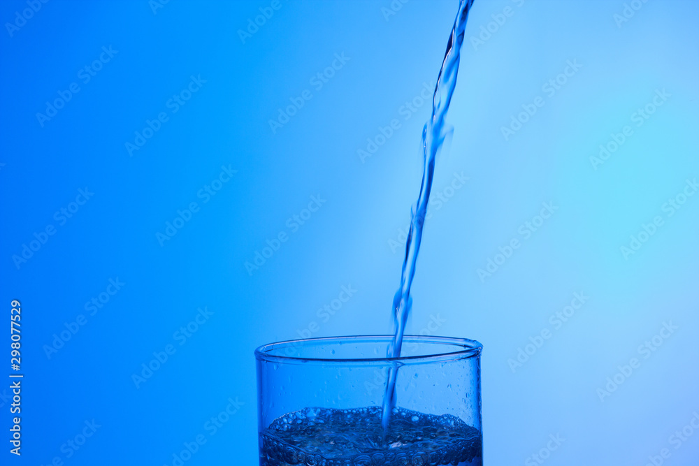 Agua entrando en un recipiente transparente de crital o plástico; agua ...