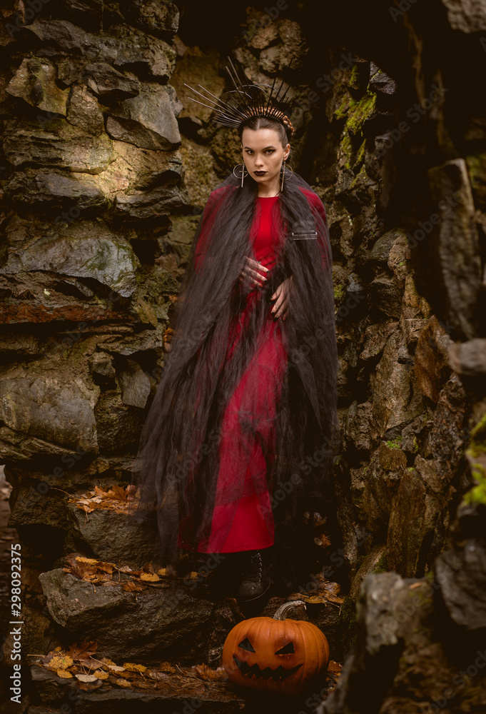 woman witch in red dress in a medieval castle.The medieval queen. Evil ...