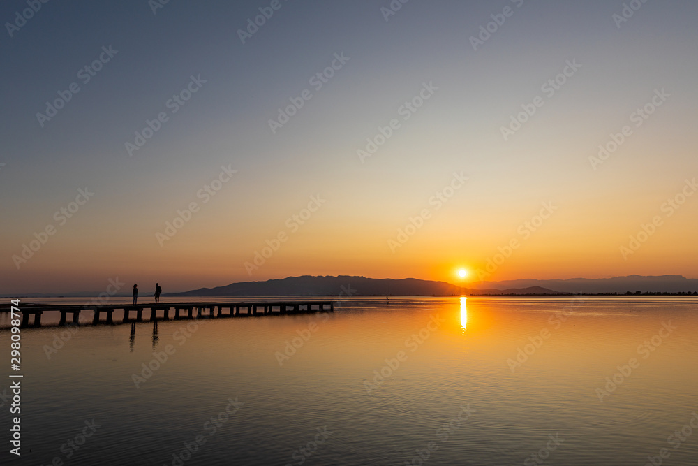 Romantic scene of a couple at sunset. Intense colors of a sunset with ...