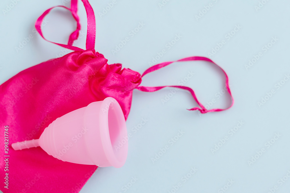 pink menstrual Cup and bag on blue background. woman period concept ...