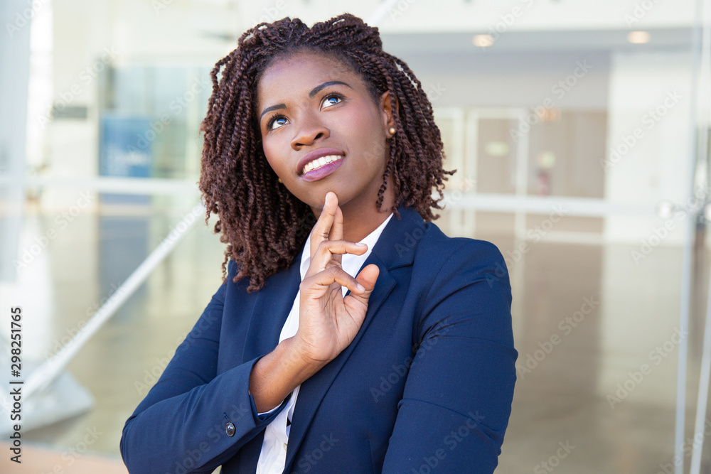 Foto de Pensive smiling professional thinking outside. Young black ...
