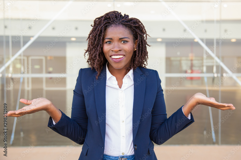 Cheerful confused female manager posing outside. Young black business ...