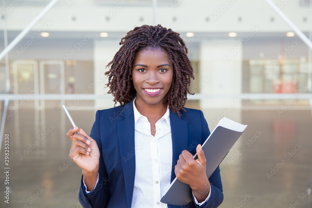 Happy successful assistant posing outside. Young black business woman ...