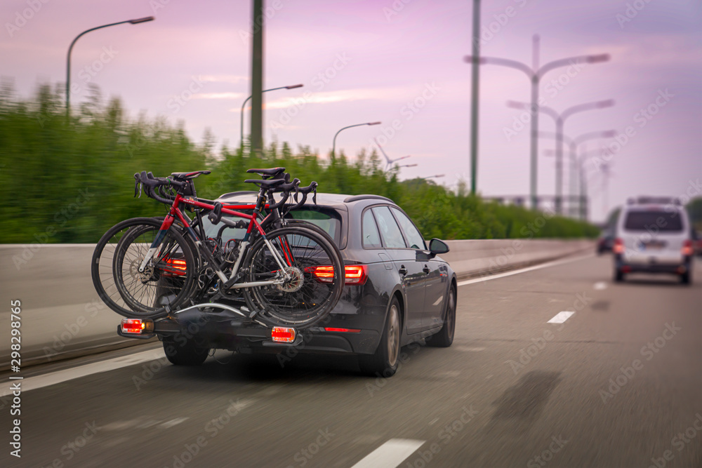 Car transports bicycles on a rack on highway in early morning Stock ...