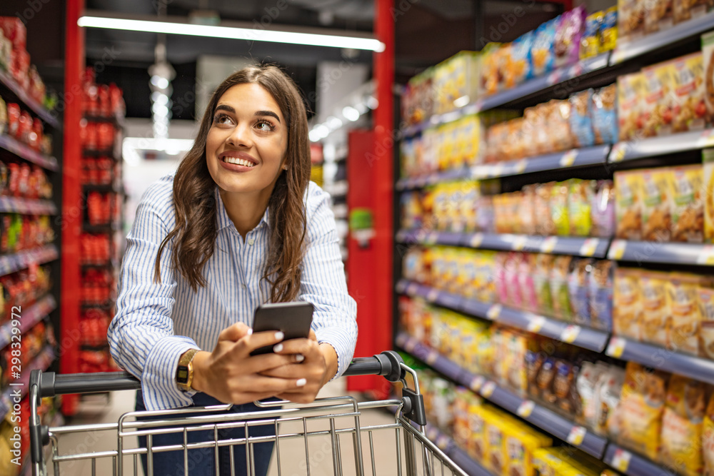 Foto de Smiling woman at supermarket. Happy woman at supermarket ...