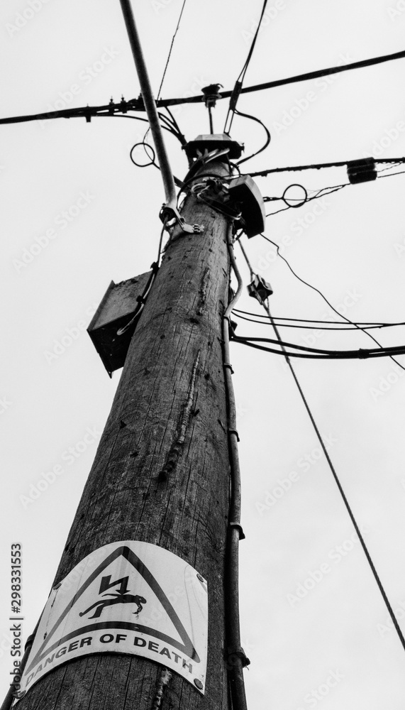 Old wooden telegraph pole seen next to a cottage showing a standard ...