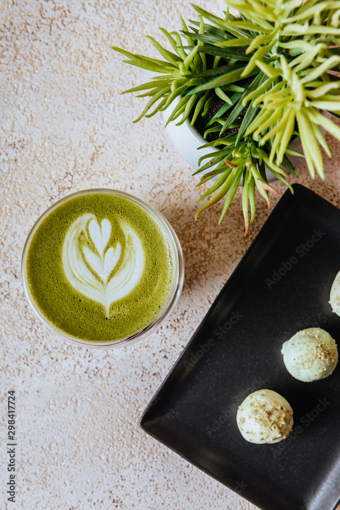 hot mocha green tea latte with candies on light texture background ...