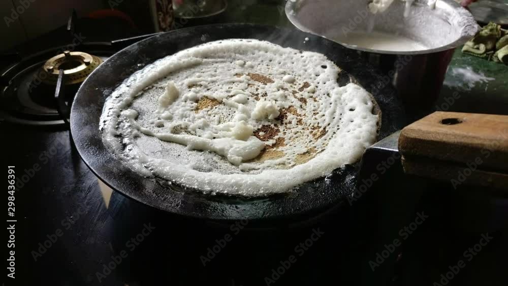 Video Stock Home made dosa being made by a woman on a old tawa and gas ...