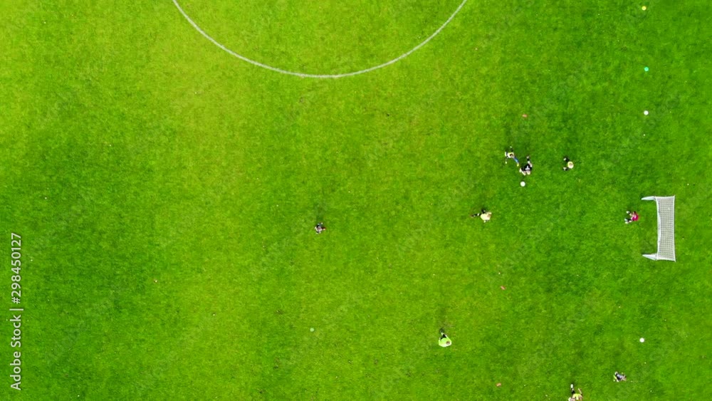 Drone top-down shot of kids playing soccer. Team scoring a goal at ...