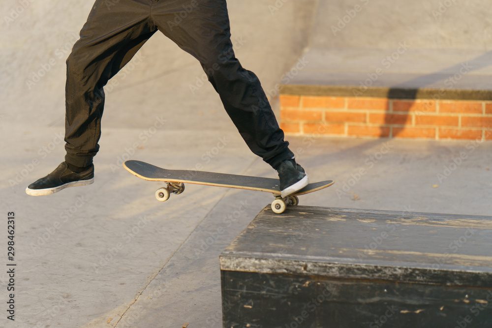 Young skateboarder performs a trick in the city skate park. Young man ...