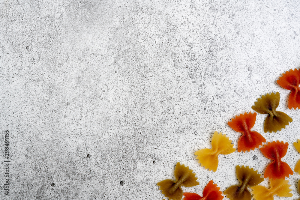 Types of uncooked pasta. Green, yellow and red pasta farfalle dry on a ...