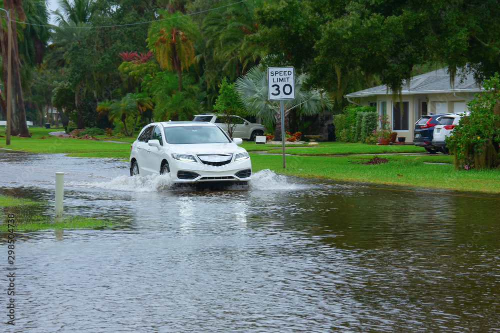 Heavy flooding and storm surge in residential neighborhood with a car ...