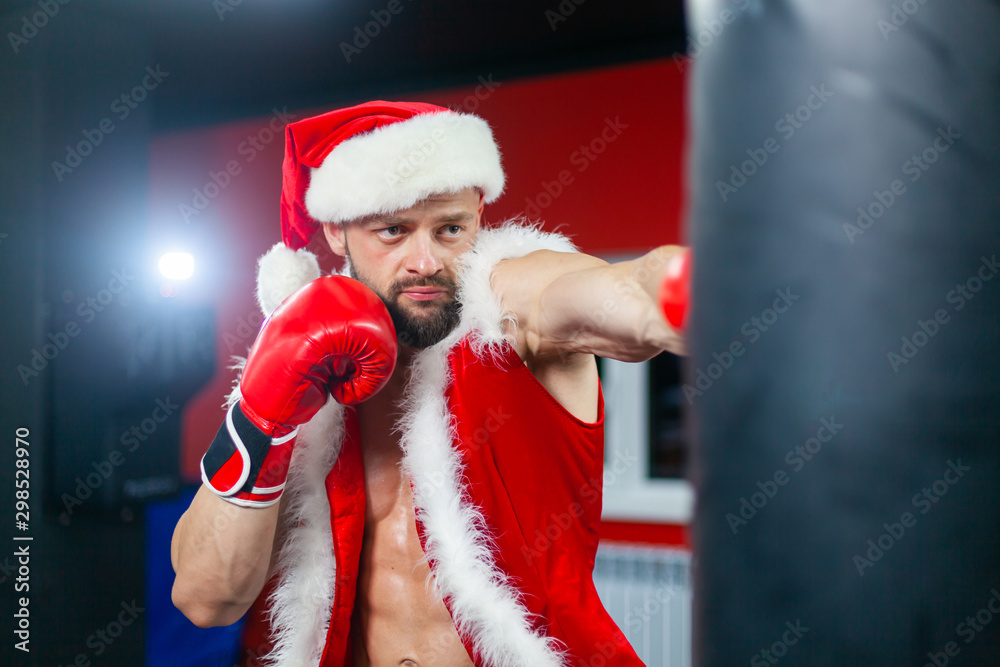 Christmas. A handsome muscular man in a Santa Claus suit with Boxing ...