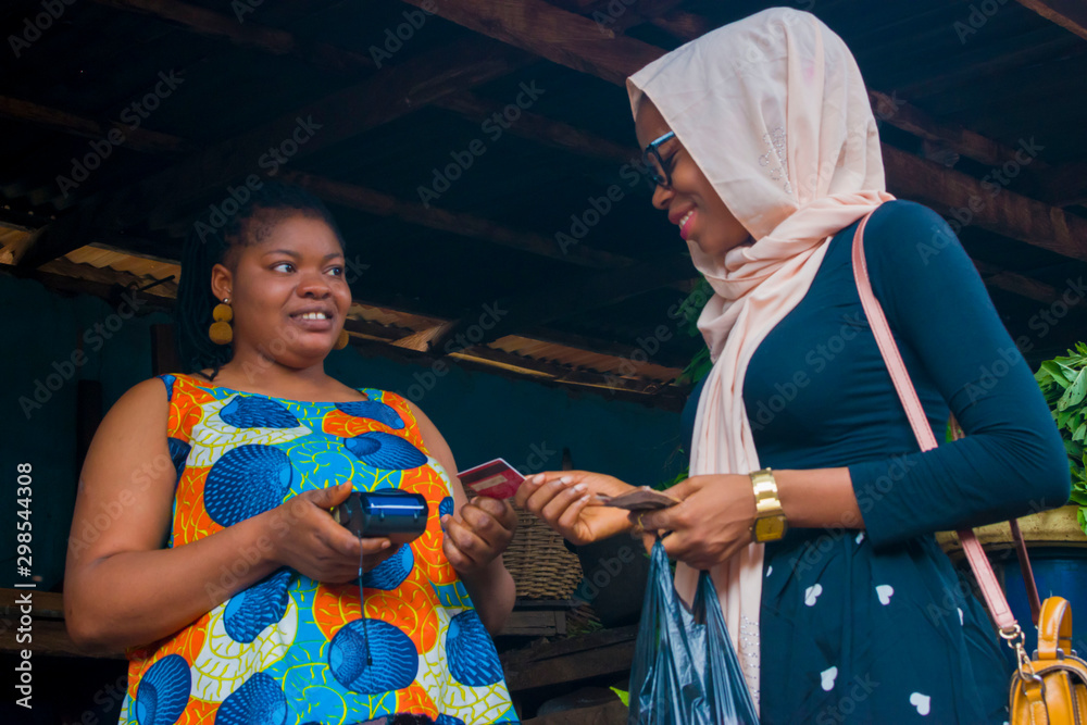 market woman receiving credit card from her customer to pay her bills ...