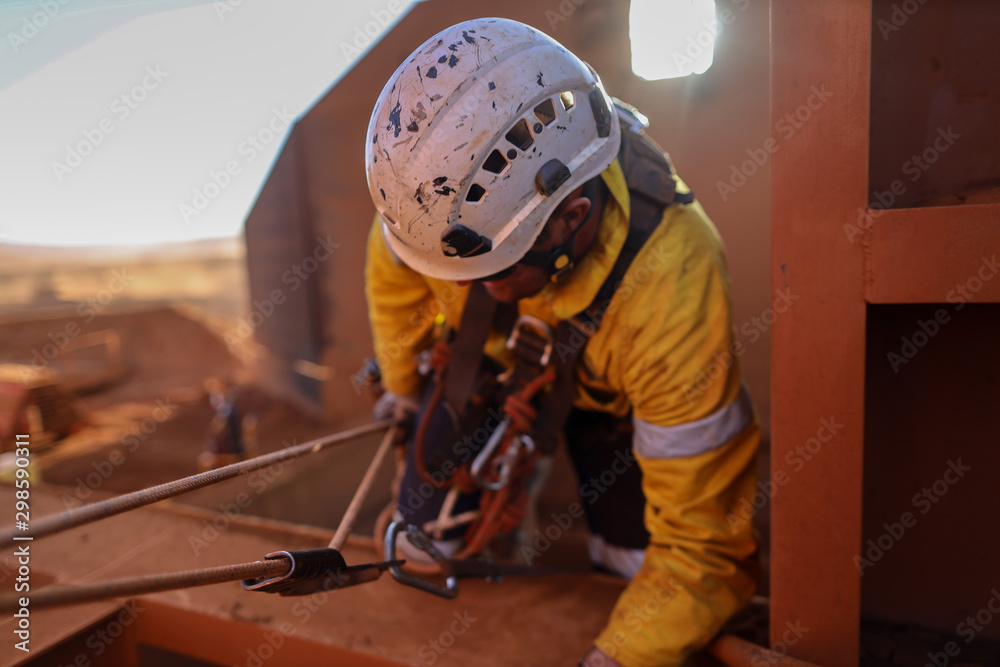 Rope access industry abseiler welder wearing safety full protection ...