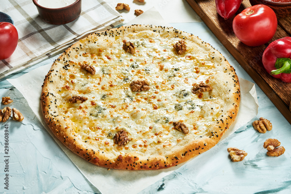 Italian fresh four cheese pizza with walnuts on a light background ...