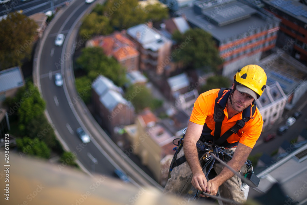 Abseiler site maintenance wearing fall protection hard hat abseiling ...