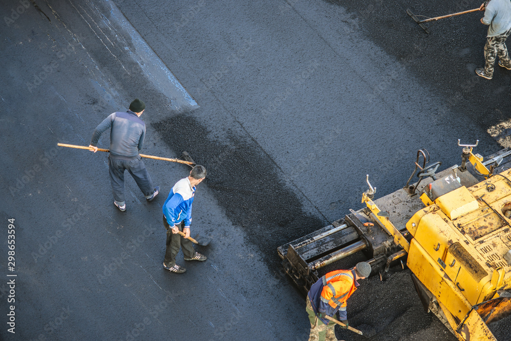 Foto Stock Workers lay a new asphalt coating using hot bitumen. Work of ...