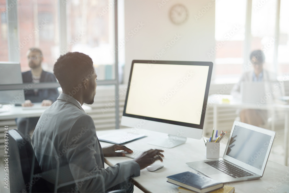 Back view portrait of African-American office worker using computer ...