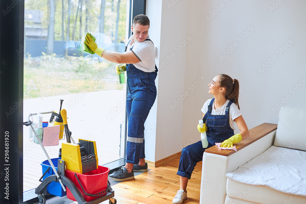 Team of young happy janitors in uniforms have conversation while ...
