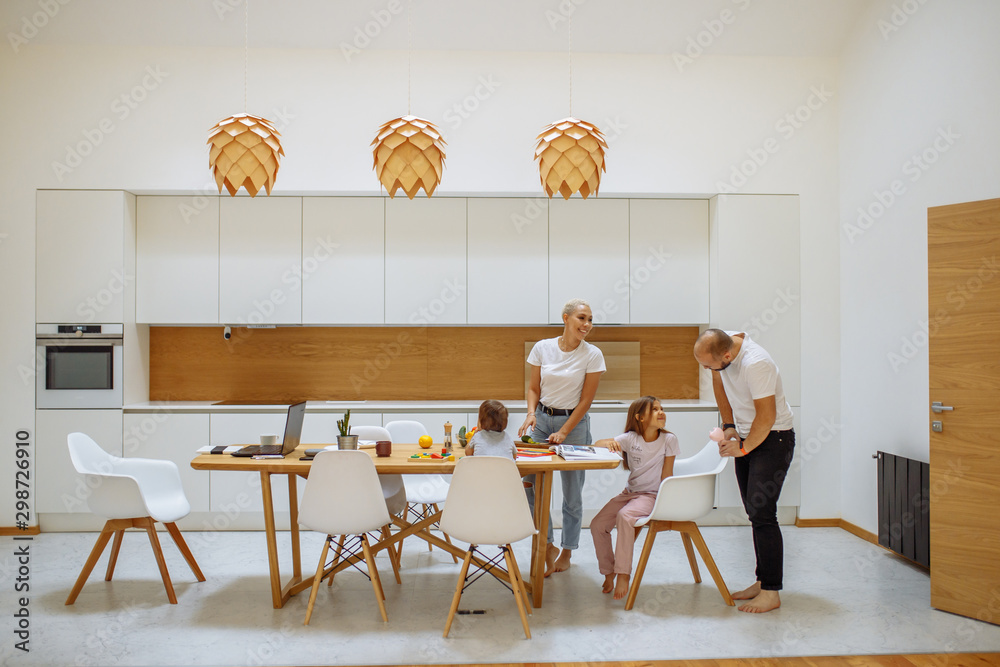 Caucasian smiling family in white kitchen with modern interior taking ...
