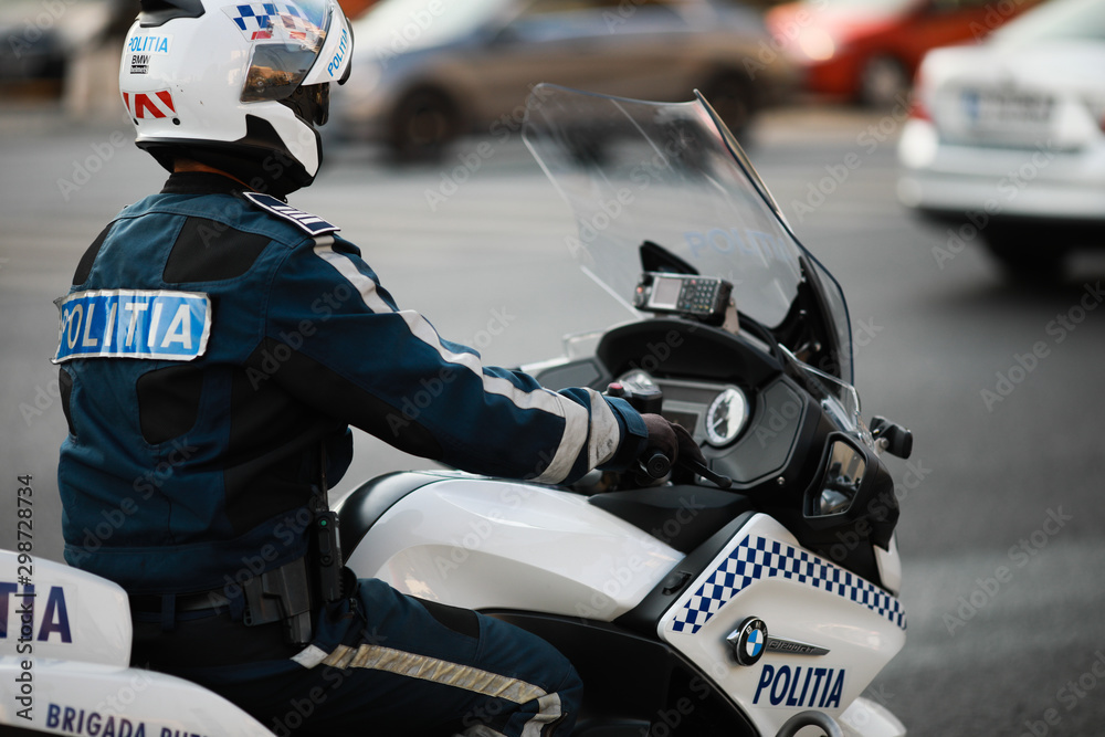 Police officer riding a BMW motorcycle in the Bucharest city traffic ...