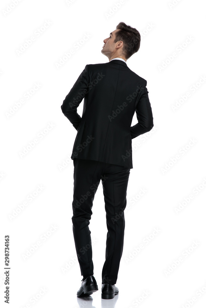 back view of young elegant man walking and looking up Stock Photo ...